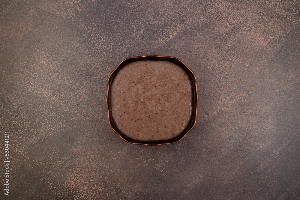 Ragi Porridge in metal bowl on brown textured background, top view ...