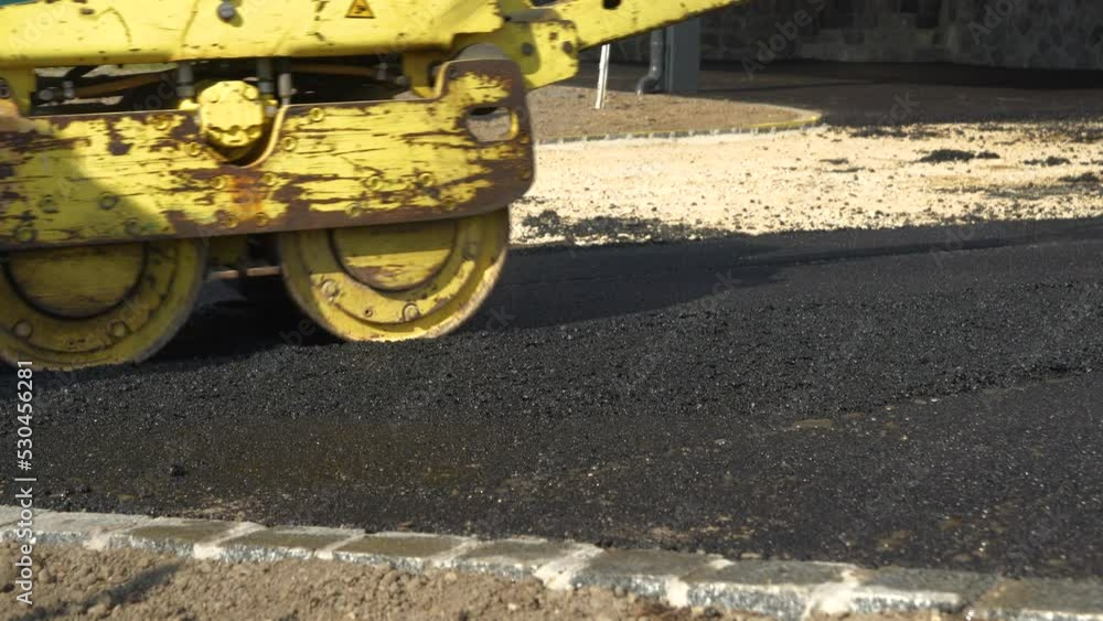 Working with asphalt roller for compacting and smoothing surface at ...