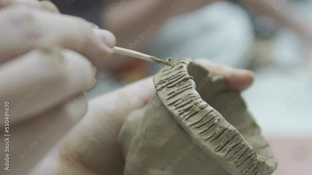 Hands are molding the clay into beautiful shapes. Man making clay ...