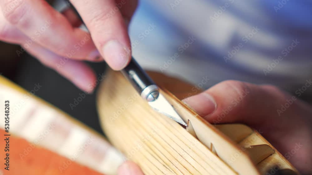 Hands of man removing excess glue from plywood details for ship model ...