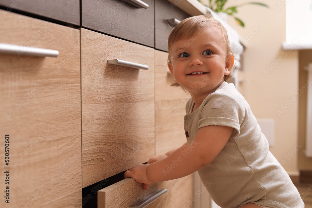 Little child exploring drawer indoors. Dangerous situation Stock Photo ...