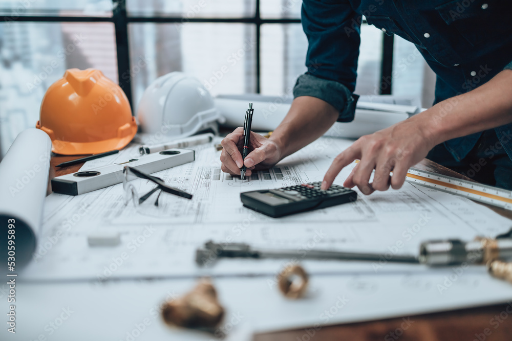 Engineering working with drawings inspection and writing on the office ...