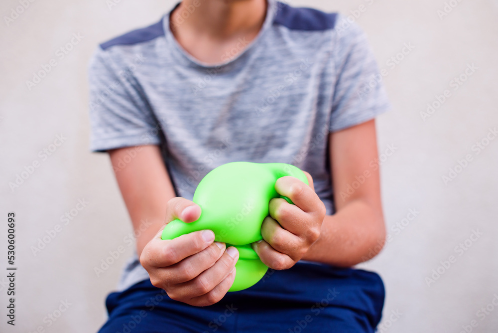 Teen boy playing with anti stress sensory ball squeeze toy. Giant ...