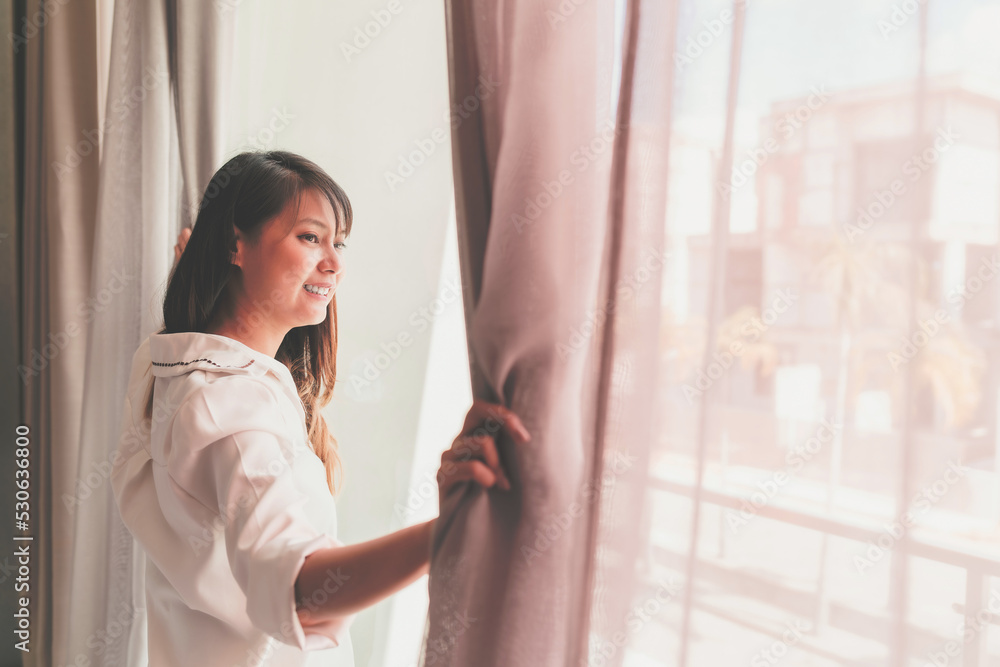 beautiful woman smile standing looking at window. pretty lady watching ...