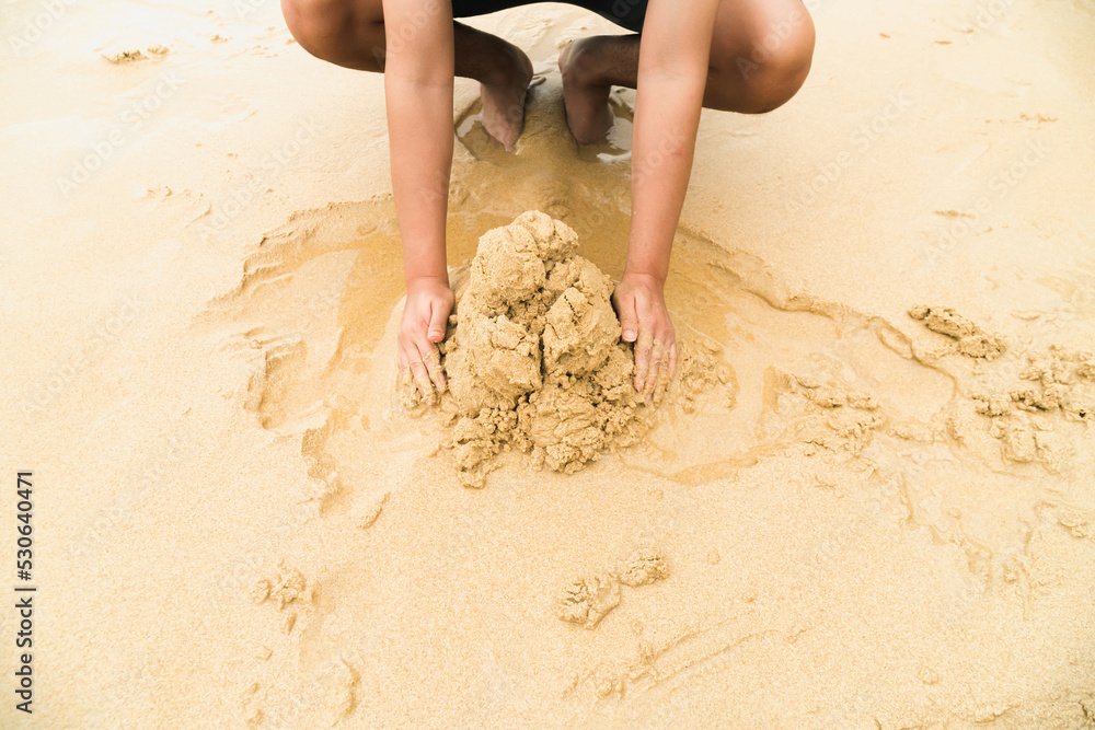 Foto de sand pile construction with bare hands. On a sandy beach, a man ...