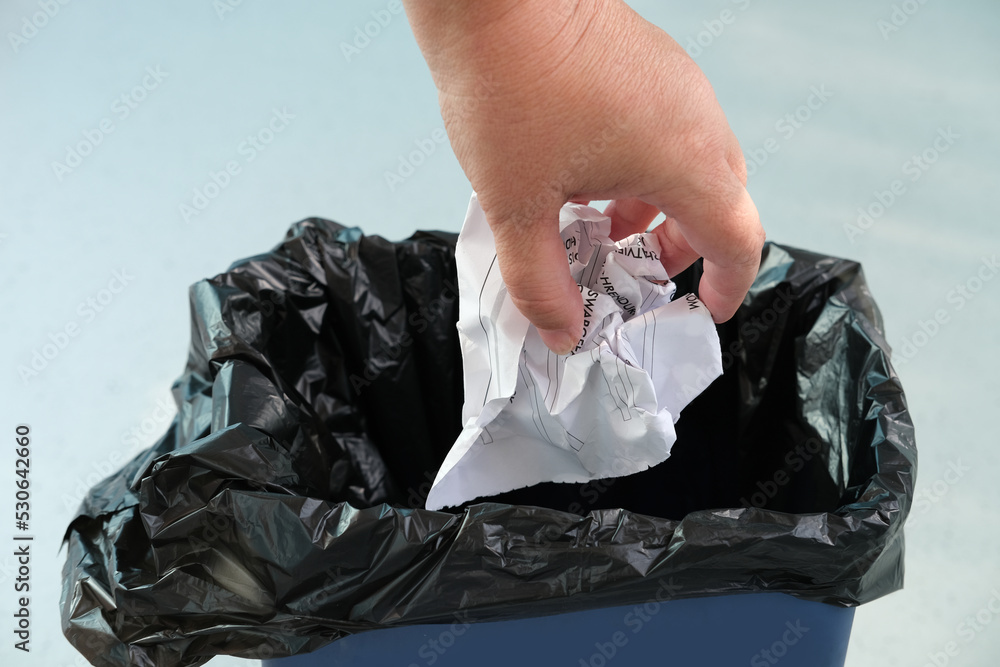woman puts wrinkled paper in a recycling bin, close-up hands, concept ...