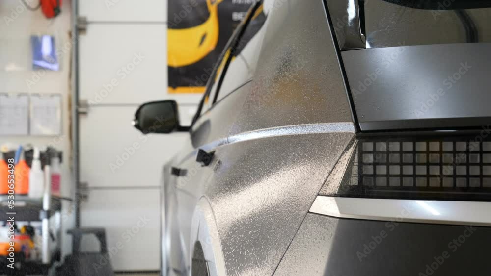 Close up to PPF installation process on a front headlight and hood. PPF ...