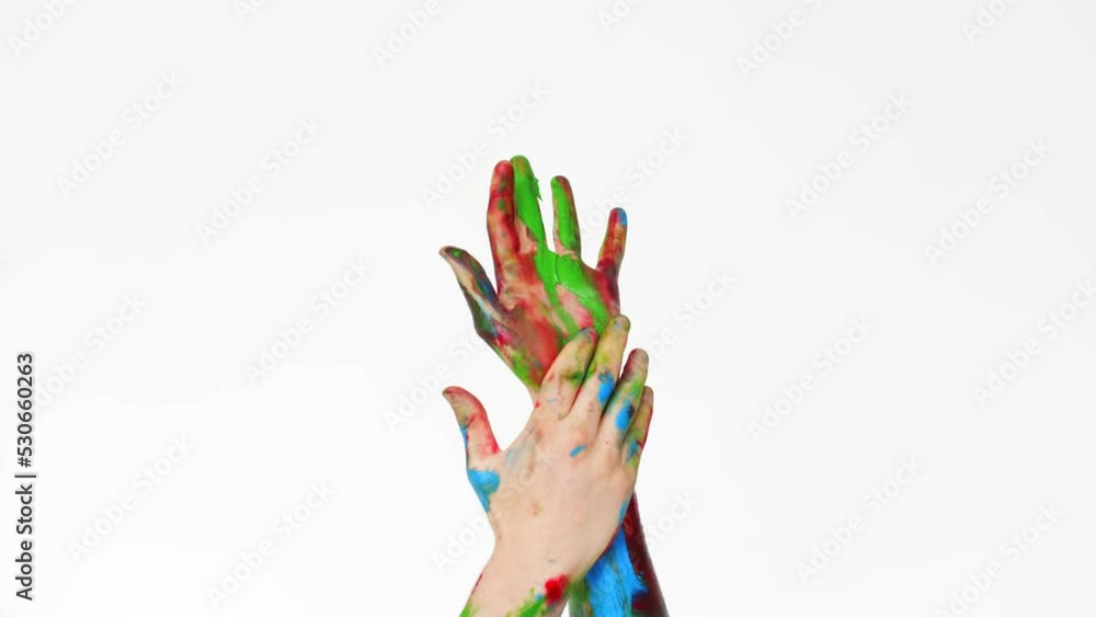 Closeup of two hands stained with brightly colored red, blue and green ...