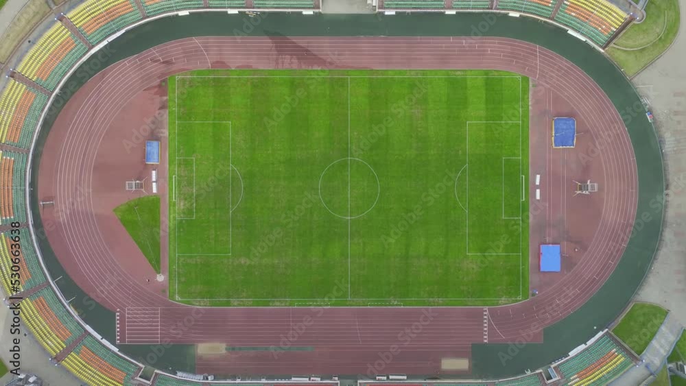 A view of a football field with gates and bleachers from a drone from a ...