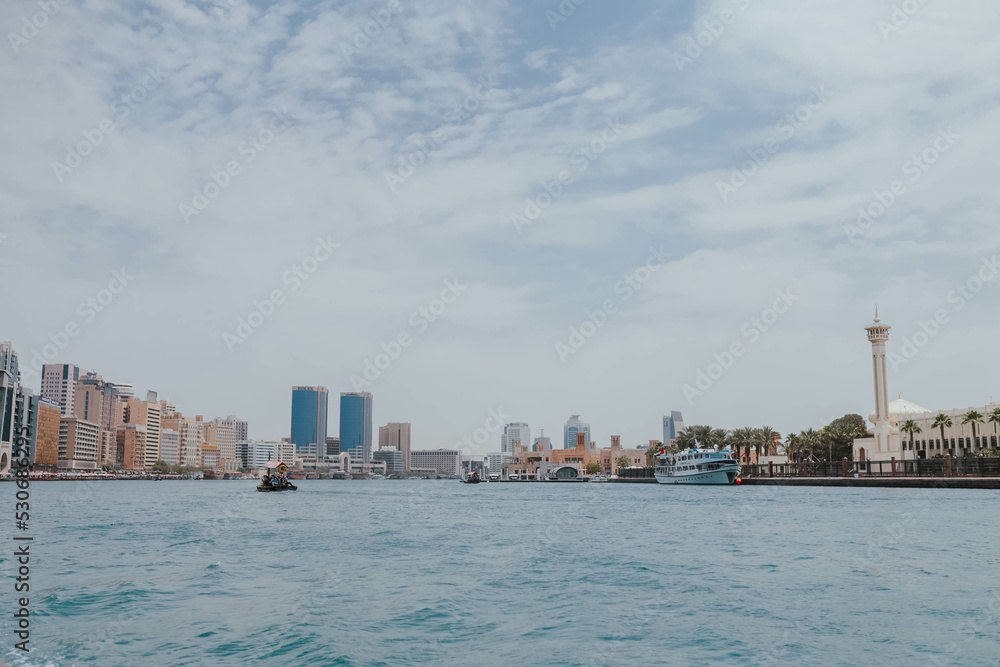 View of Dubai Creek channel with traditional Abra boats and piers ...