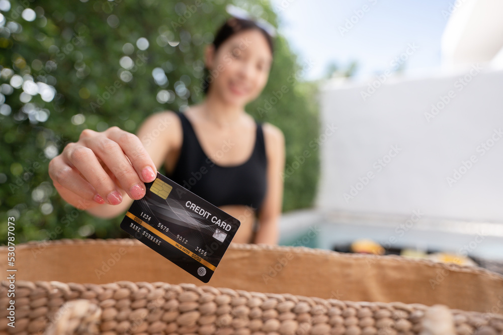 Woman show credit card with floating breakfast in the pool on luxury ...