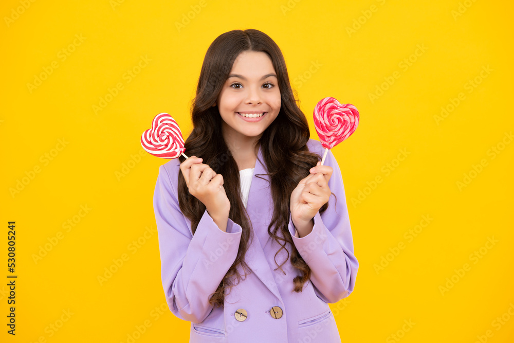 Cool teen child with lollipop over yellow isolated background. Sweet ...