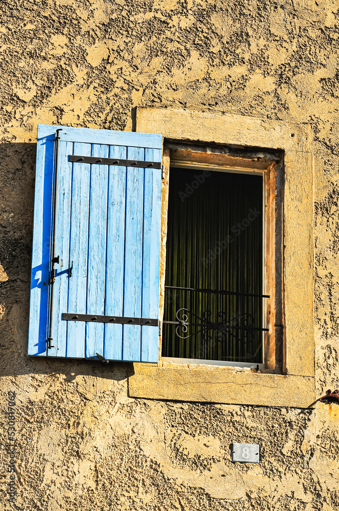 front view, medium distance of a barred window with blue, wood, shutter ...