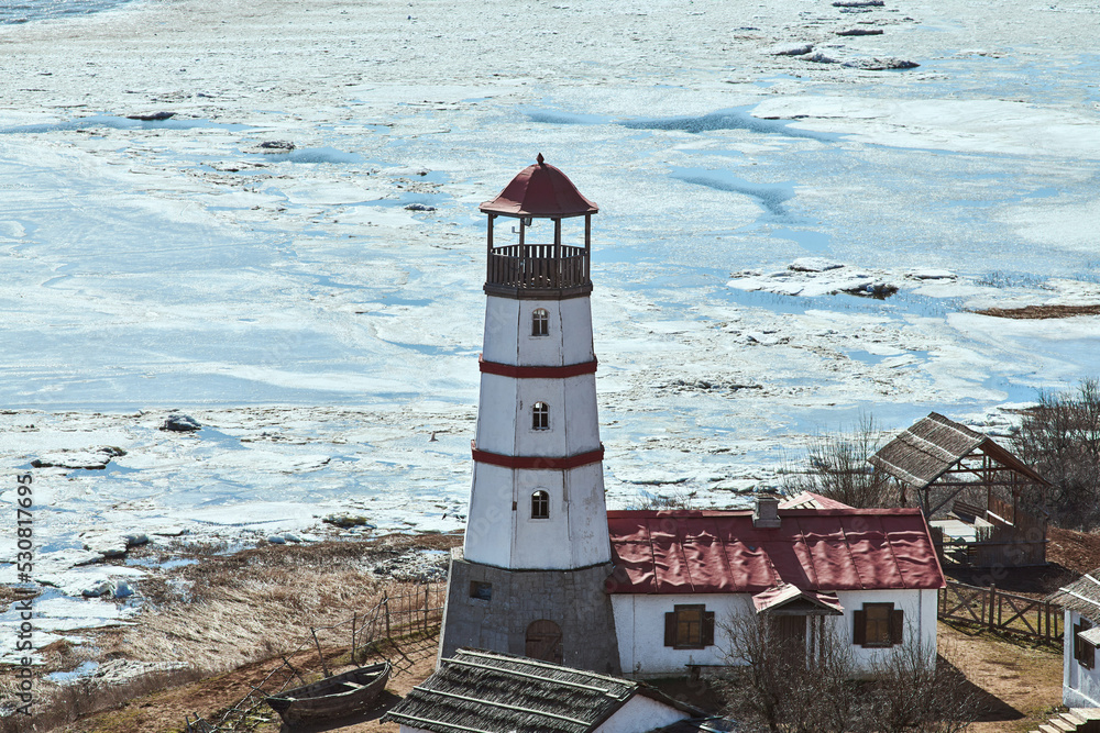 Beautiful white red lighthouse with farm utility houses in Merzhanovo ...