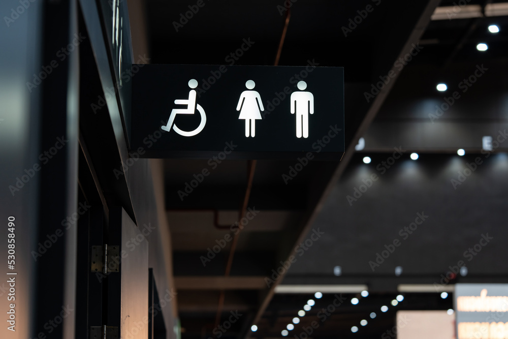 A sign of restroom lighten in white standout from a black plate. The ...