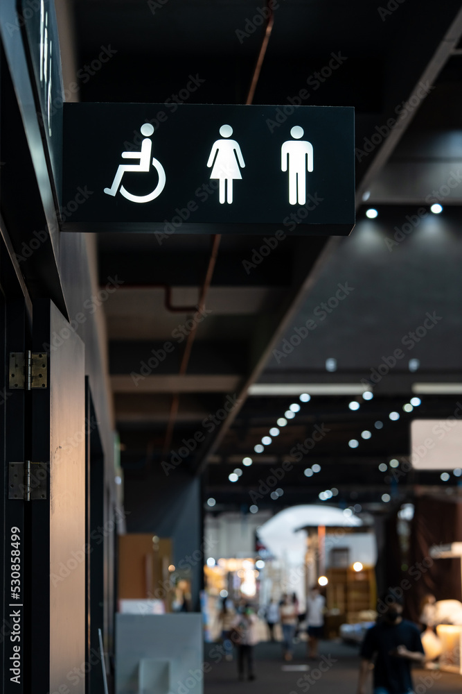 A sign of restroom lighten in white standout from a black plate. The ...