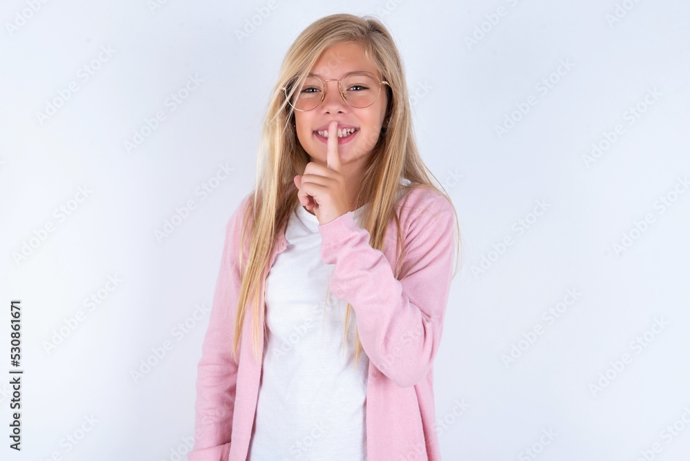 Smiling caucasian blonde little girl wearing pink jacket and glasses ...