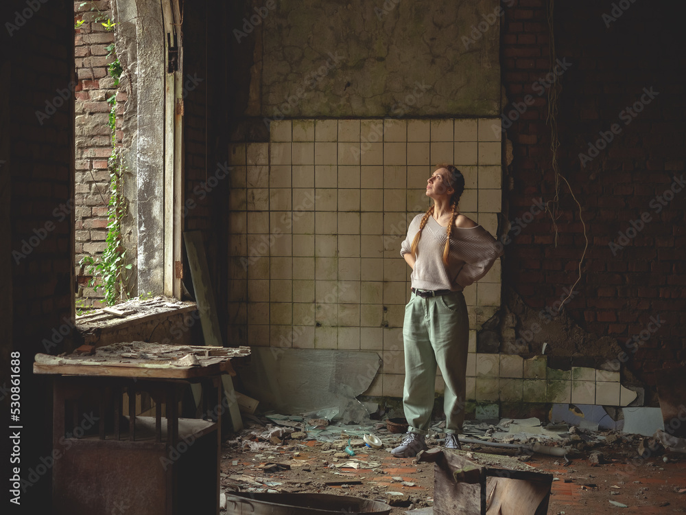 Woman inside an ancient ruined building. Old littered broken room. Walk ...