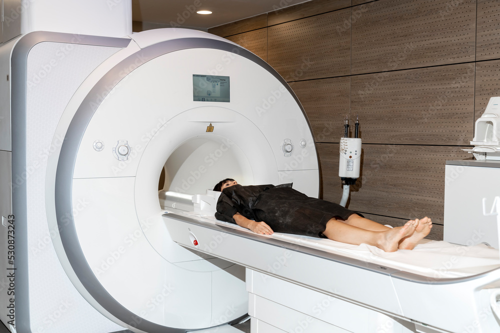 Female Patient Lying on a CT or MRI or PET Scan, Bed is Moving inside ...
