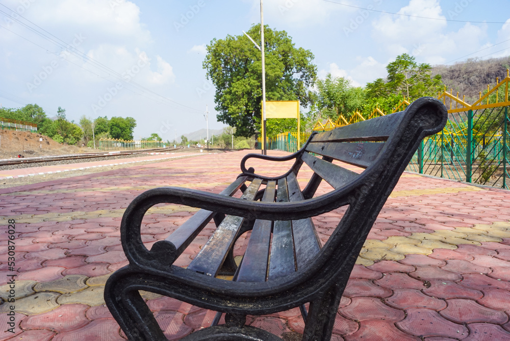 Blank railway sign board, seating bench at railway station platform of ...