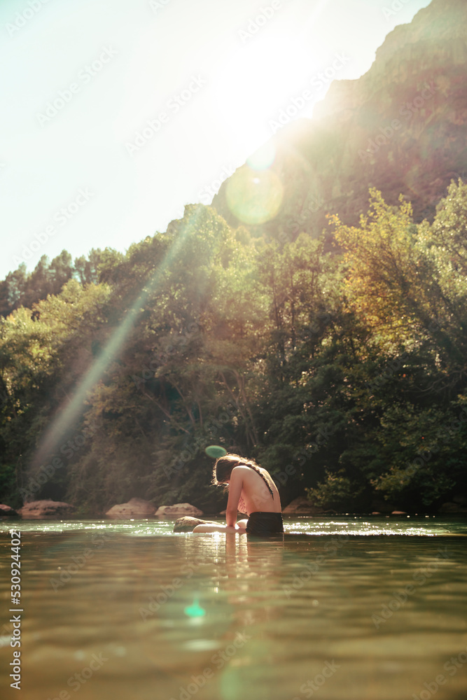 Naked girl bathing in a river surrounded by trees during sunset Stock ...