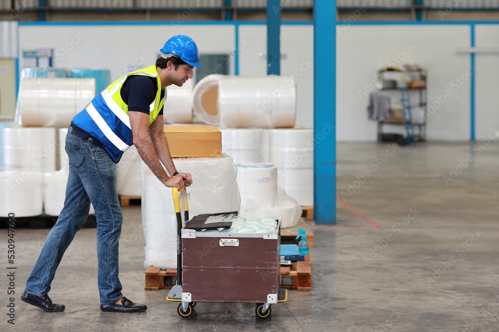 Warehouse worker pulling a pallet truck and taking or upload package ...