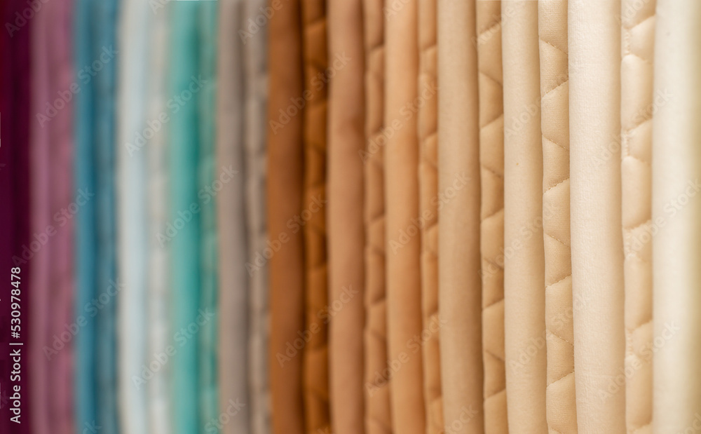 Fabric swatches in different colors are stacked for selection. A ...