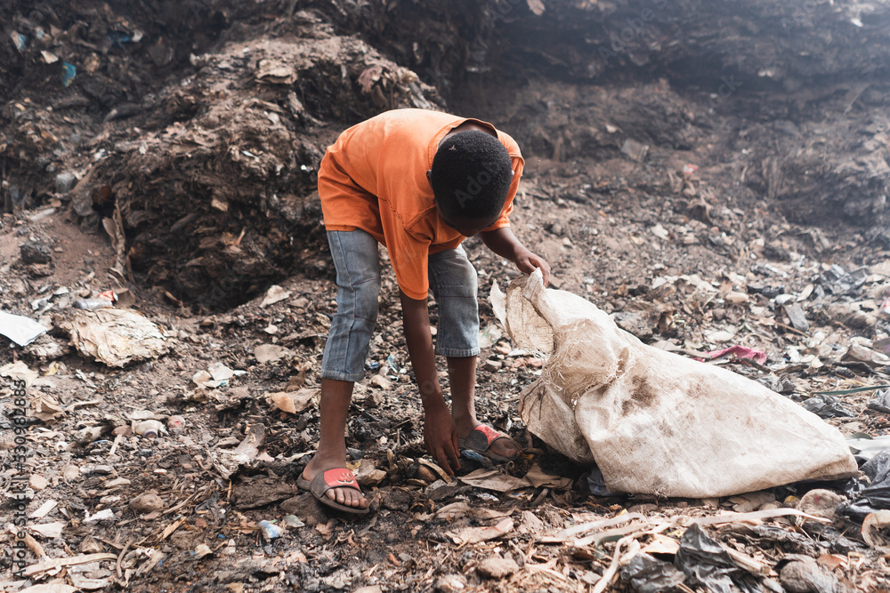 Young garbage picker working hard in an African landfill amidst dirt ...