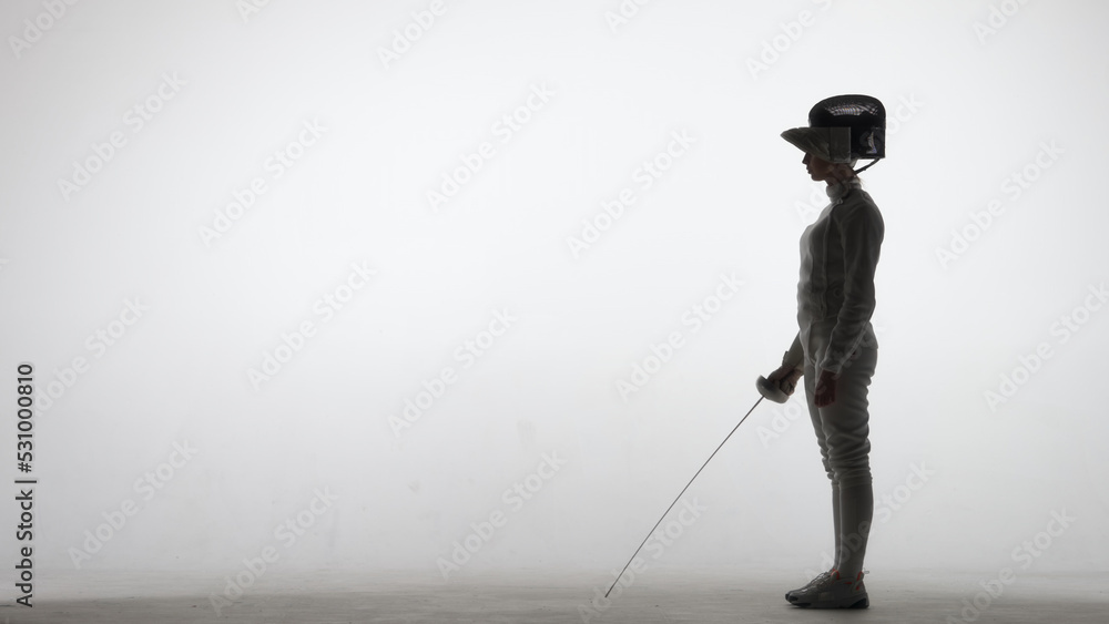 Side view of young female swordswoman with rapier. Athlete fencer in ...