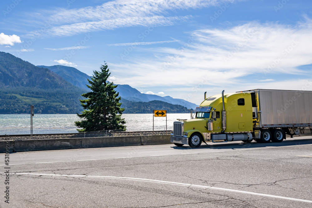 Bright yellow old classic big rig semi truck tractor transporting food ...