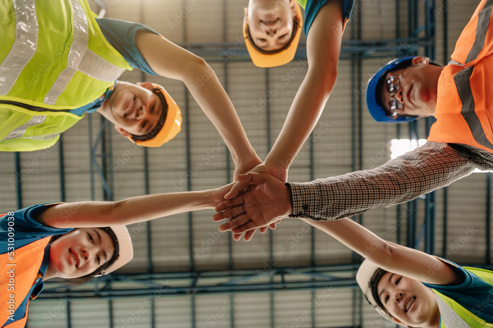 Happiness engineer and worker team group joining hands at cargo ...