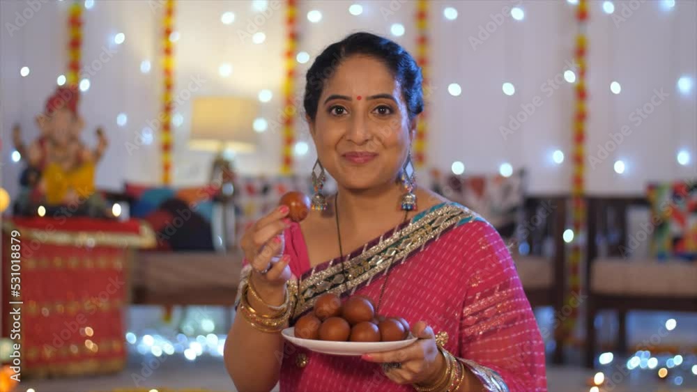 A middle-aged woman with Gulaab Jamuns plate in her hand - Indian ...