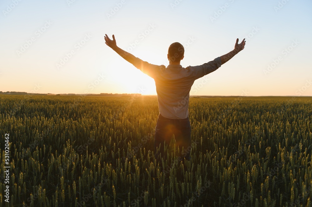 Sunrise or sunset picture of guy with raised hands looking at sun and ...