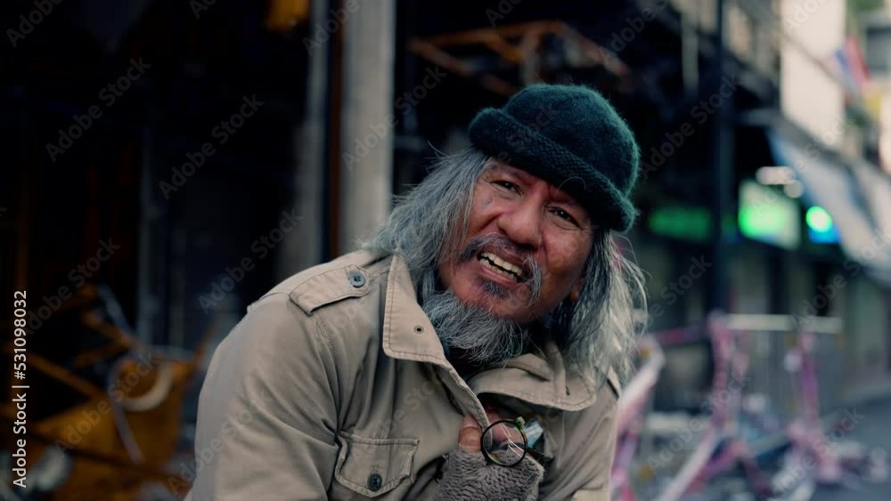 4K, An old, homeless Asian man standing on the side of the road showing ...