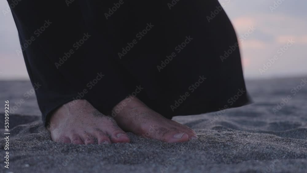 Slow motion close-up view of female feet covered by sand under long ...