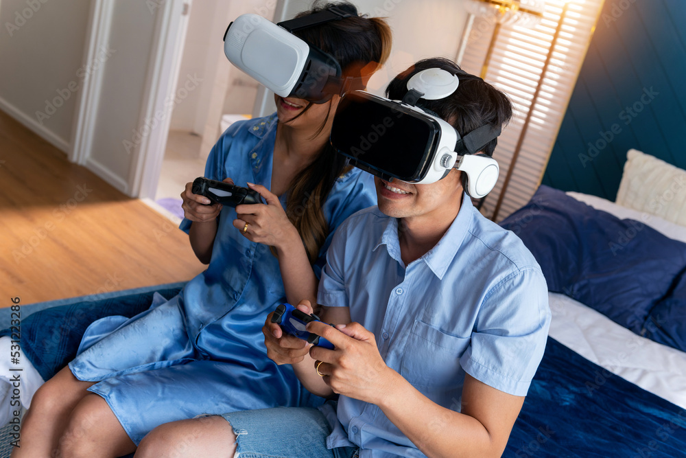 excited married couple play vr glasses. cheerful wife and husband enjoy ...