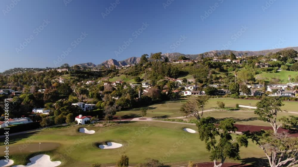 Wide aerial of Montecito golf course and luxury homes with mountain ...