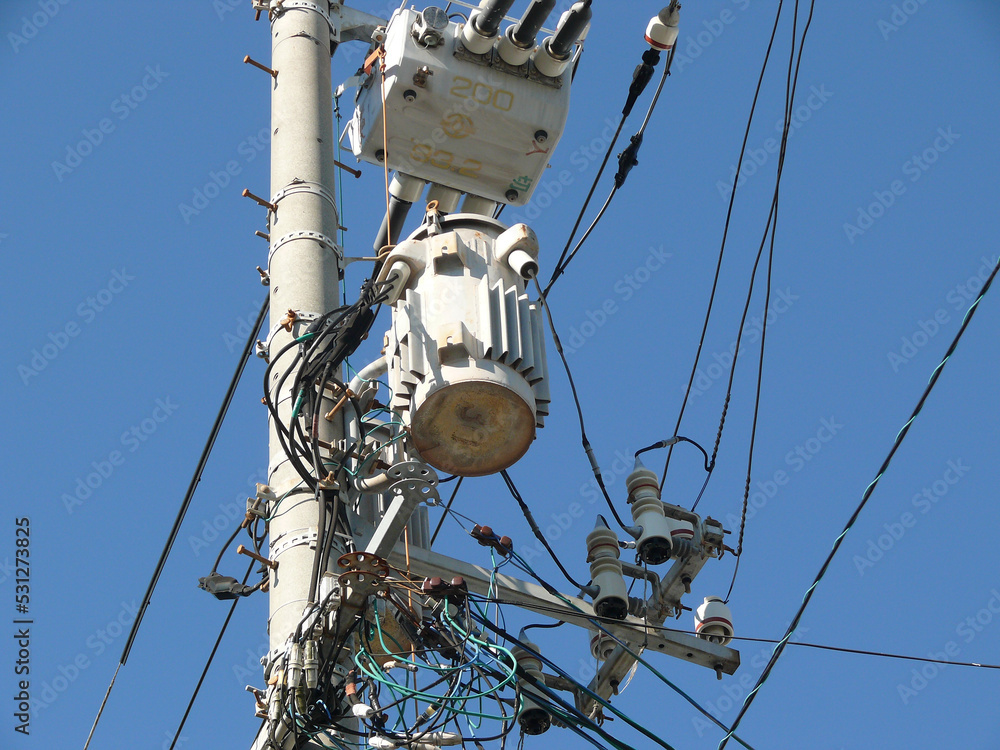 高電圧開閉器。 A high voltage circuit breaker at the top of a utility pole in ...