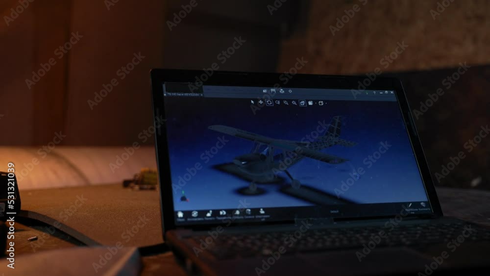 Person uses program of 3D models on laptop screen to make aircraft. Man ...