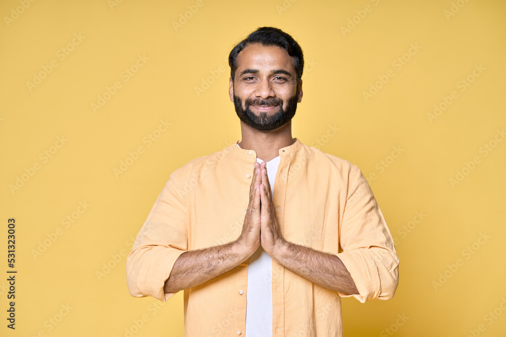 Mindful happy bearded indian man praying in meditation holding hands in ...