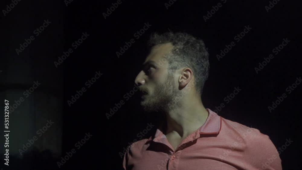 The man looking around in the dark in his dream. Lights are flashing in ...