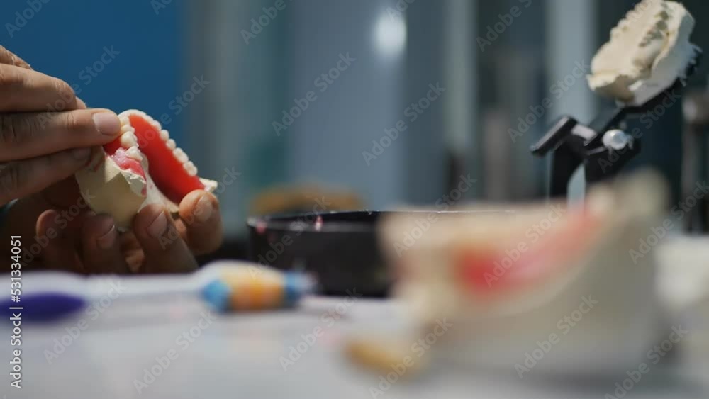 close-up of the process of making a removable denture by the hands of a ...