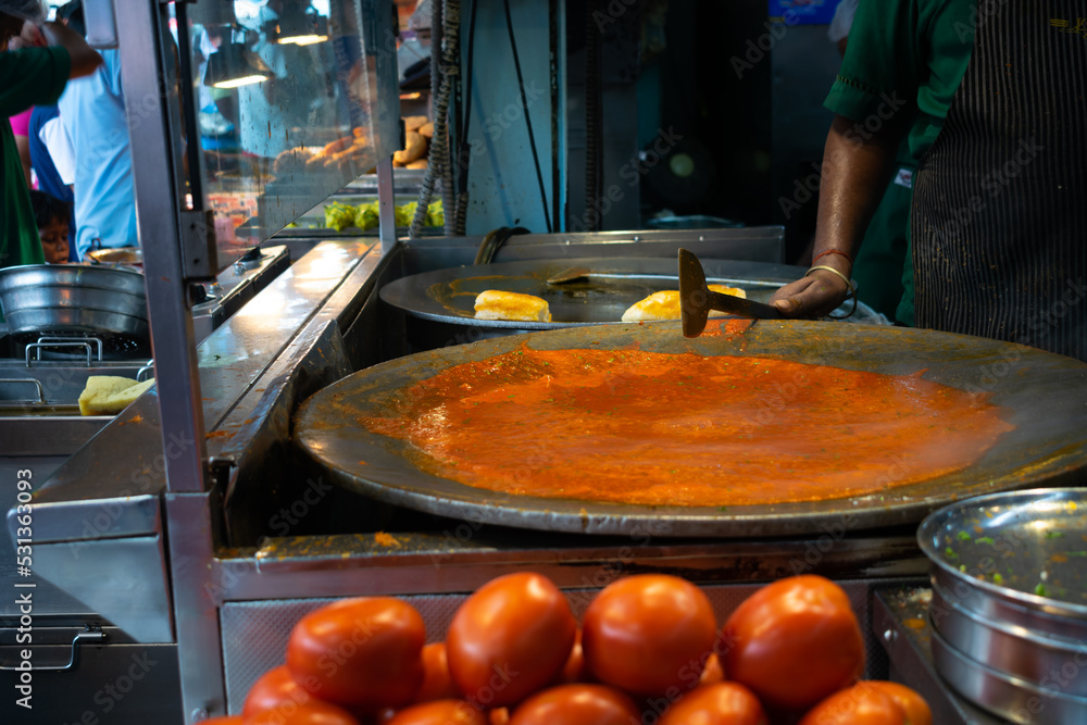 Picture of big pan and hot curry(Pav Bhaji) at a restaurant. Tomato ...