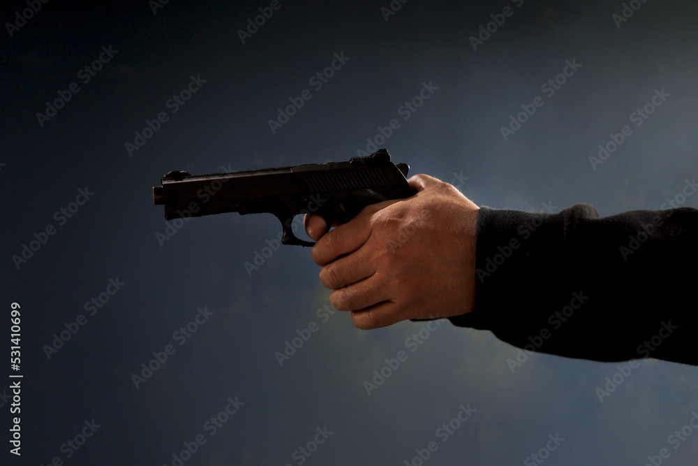 Criminal man hand holding a gun pointing victim, Mask thief robber with ...