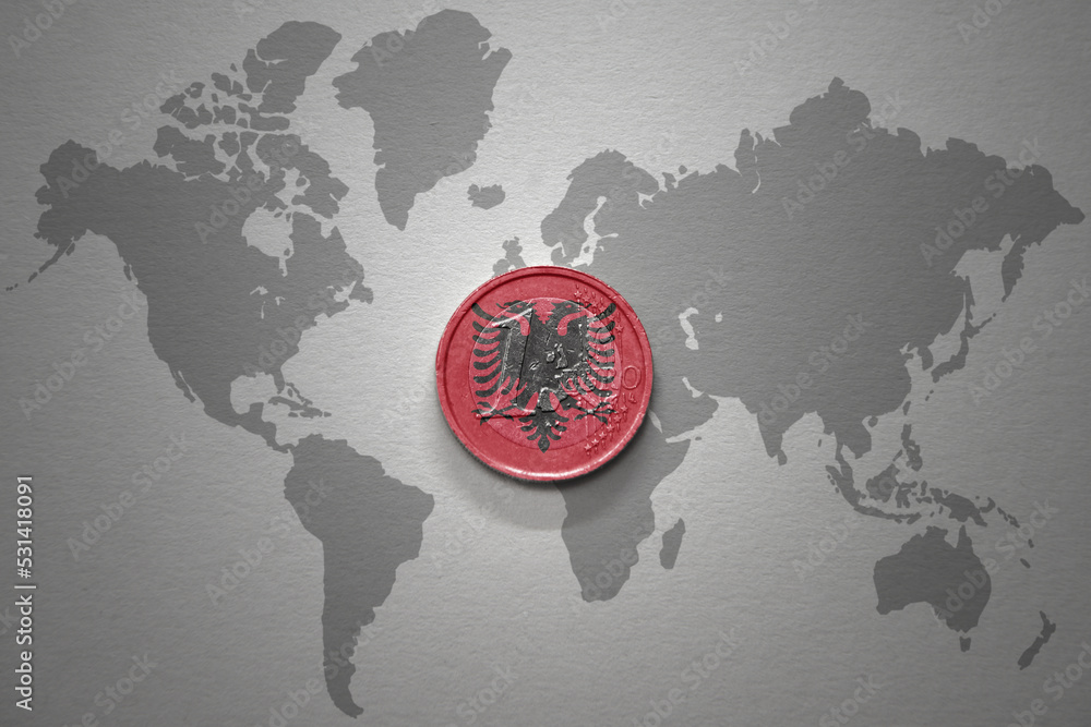 euro coin with national flag of albania on the gray world map ...