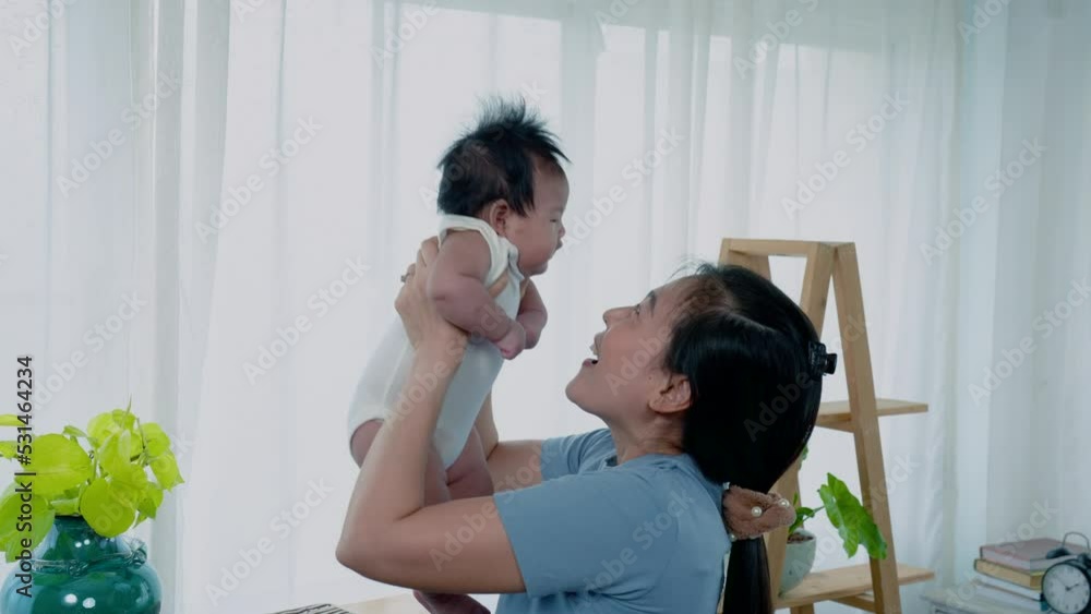 Video „4K, Asian single mom, holding up his daughter, teasing his daughter by holding it up and ...