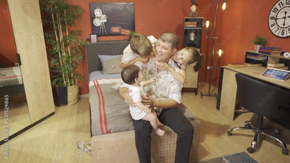 Children kiss dad on the cheek. Children hiding behind dad kisses on ...