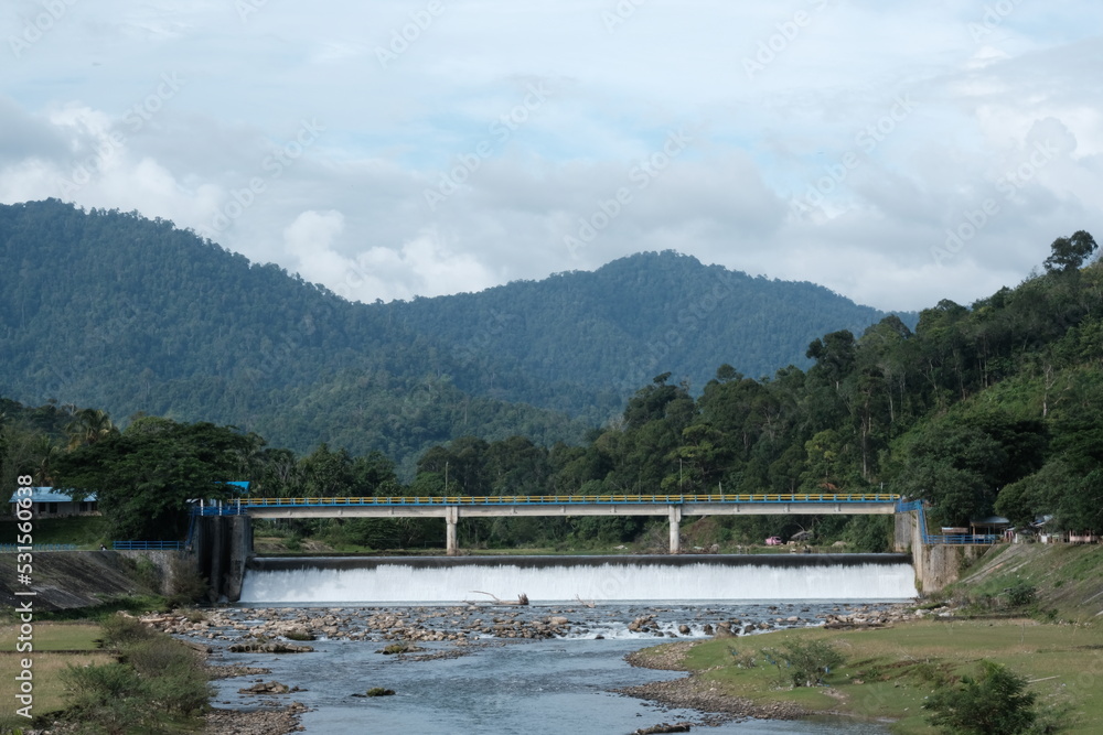 This is a view of the dam with the rapid flow of water and the blue ...