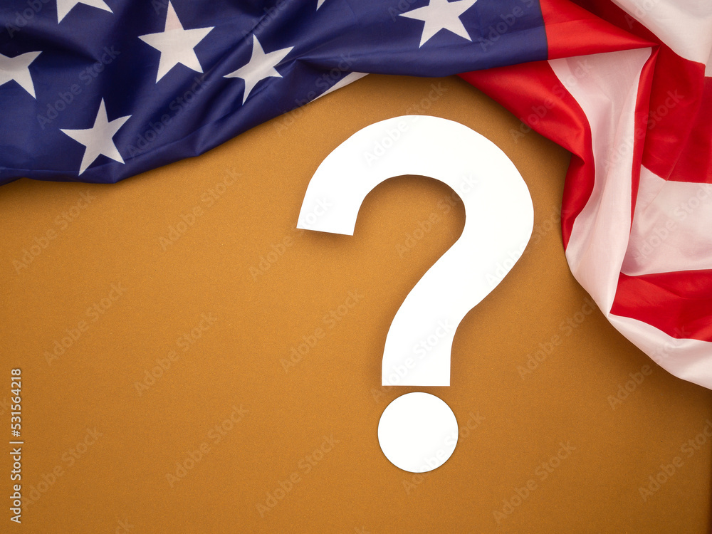 White question mark over a brown background with the American flag on ...