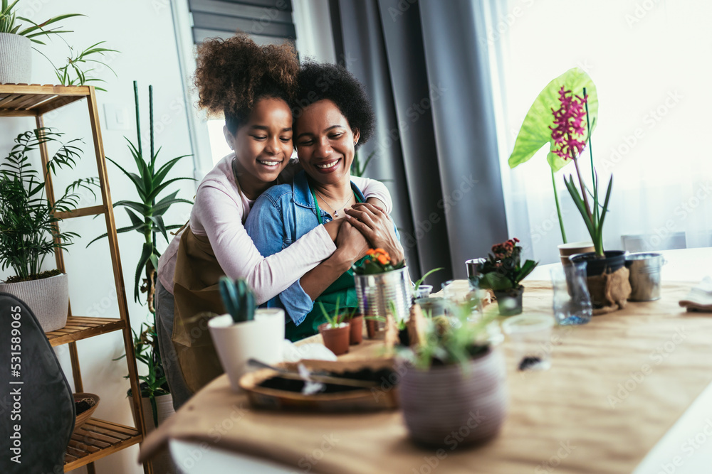 Mother and daughter planting at home, spending time together and having ...